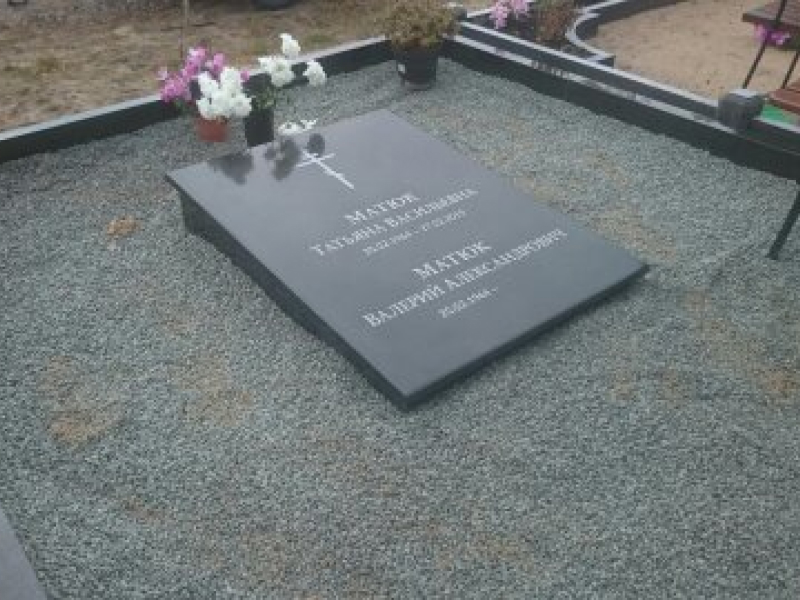 Granite closed grave slab with a sloped surface